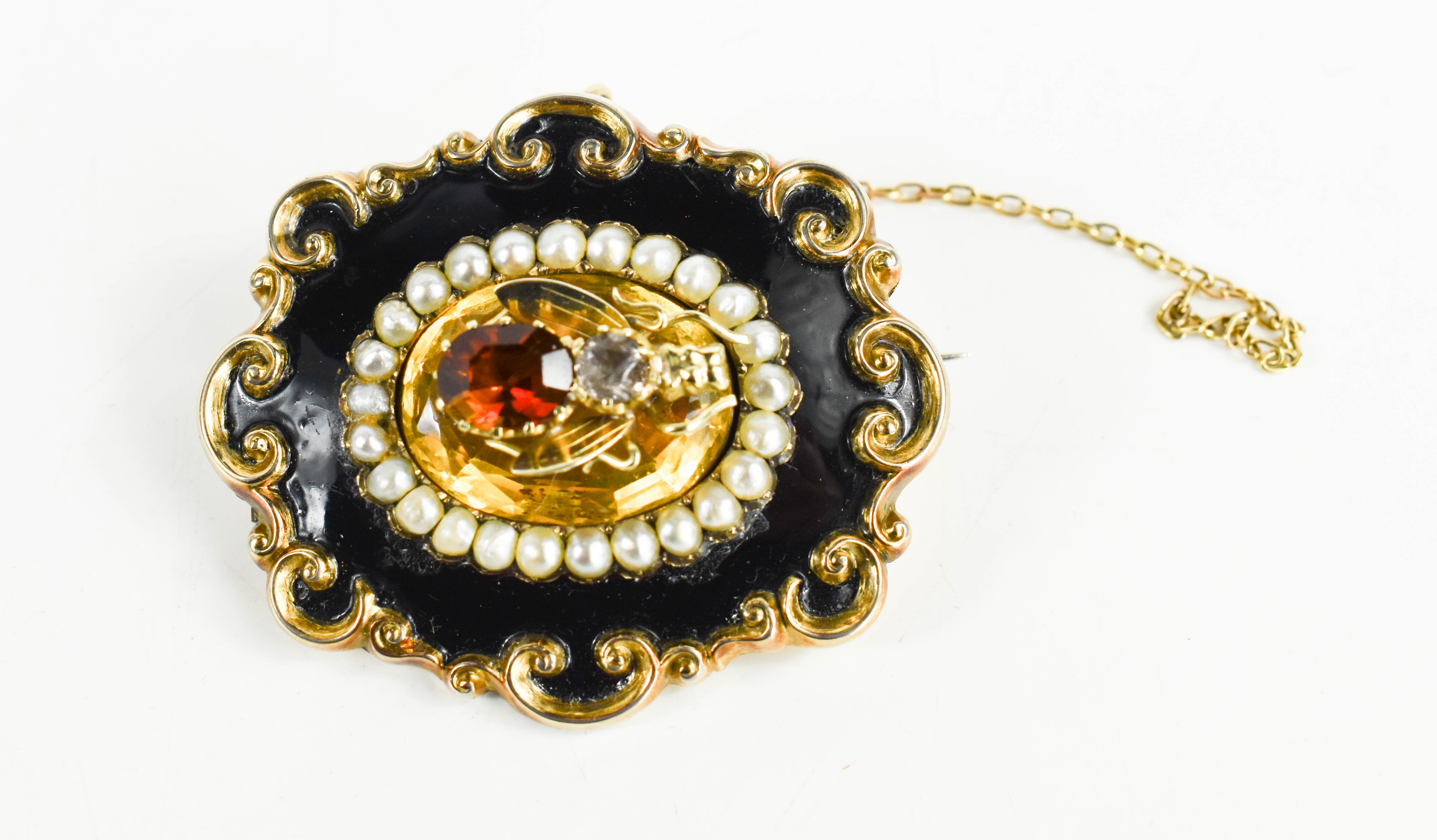 Lot 4 - A Victorian mourning brooch, the rococo scroll