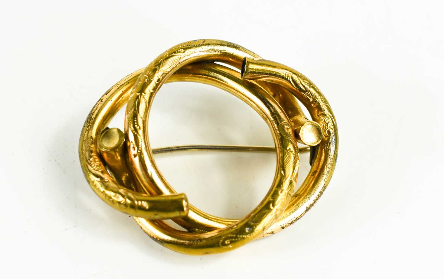 Lot 145 - An 18ct gold loop knot brooch, with engraved