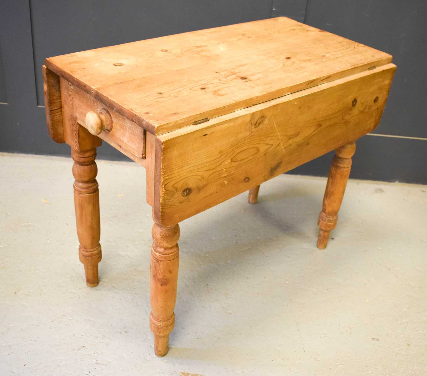 Lot 388 - An antique pine drop leaf kitchen table with